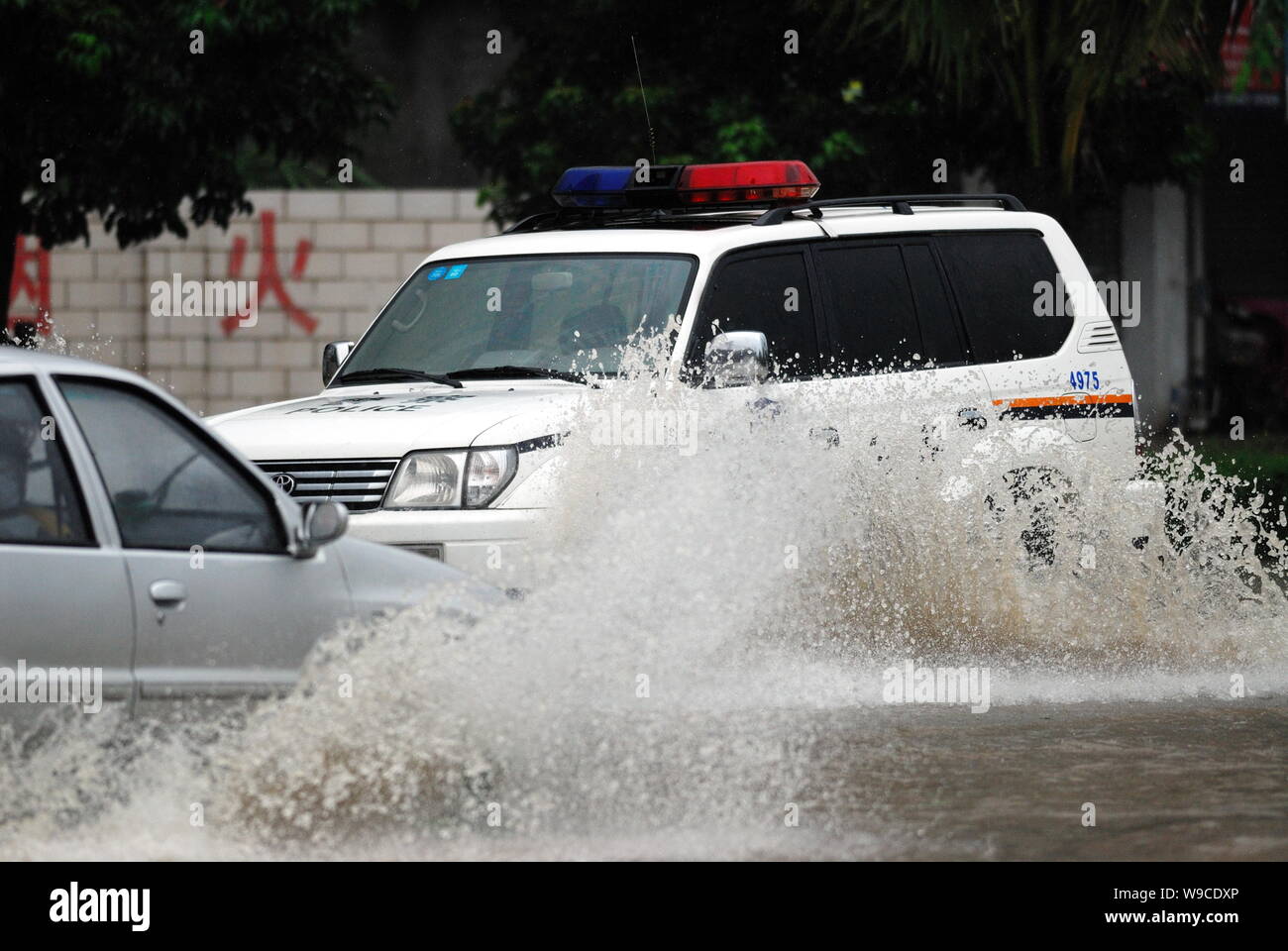 Cars drive through a flooded street after heavy rain caused by Tropical ...