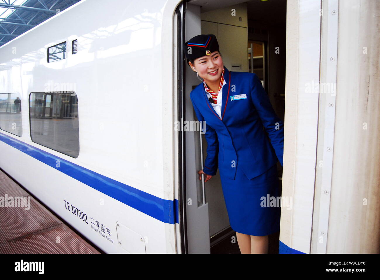 A Chinese staff stands in a CRH (China Railway High-speed) train to run ...