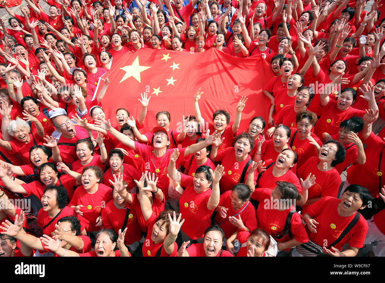 Local Chinese citizens surrounding the Chinese national flag laugh ...