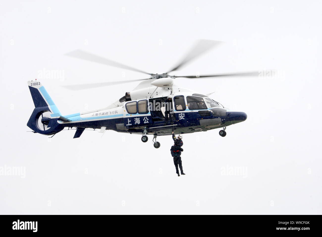 A policeman and a man acting rescuee are seen being lifted to a police ...
