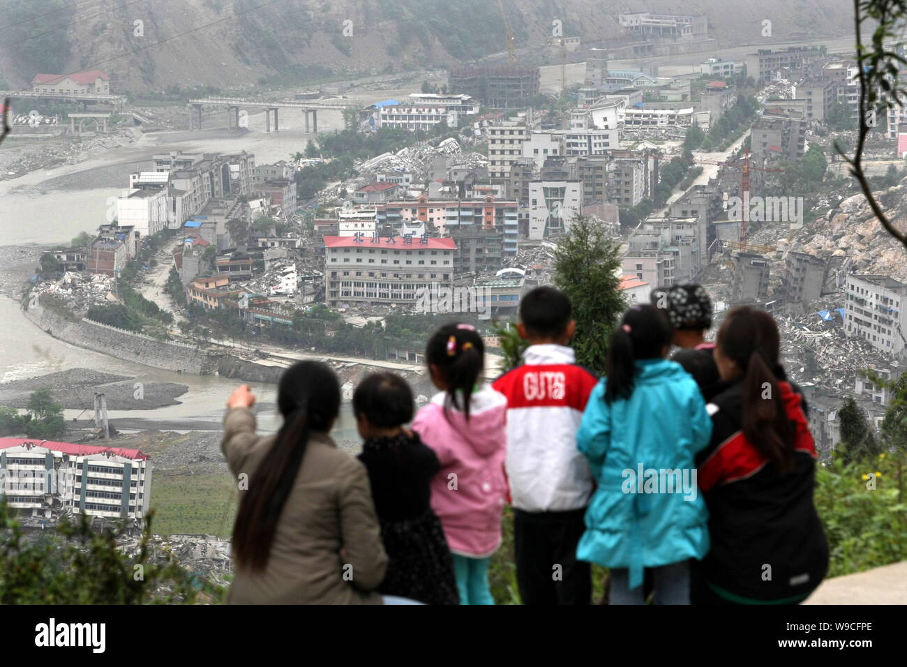 Chinese kindergarten children and their teachers on a hill look at the ...