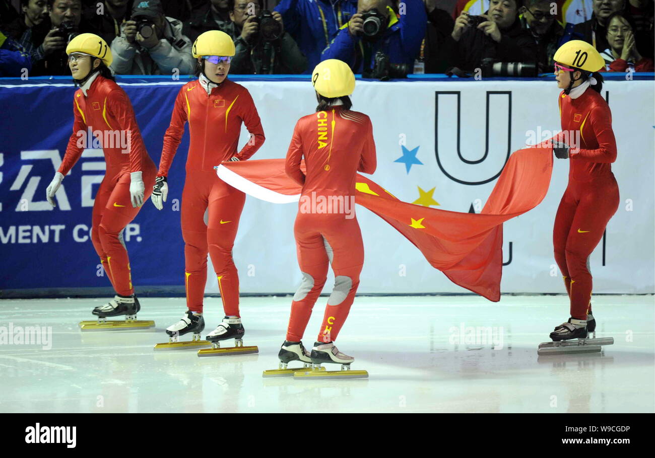 Chinese skaters show a Chinese national flag to celebrate after winning ...