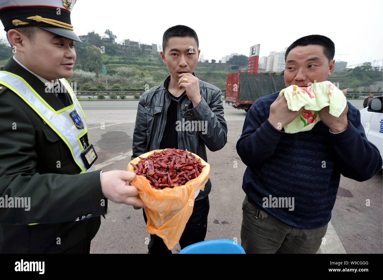 A Chinese police officer offers hot chili peppers to drivers at a ...
