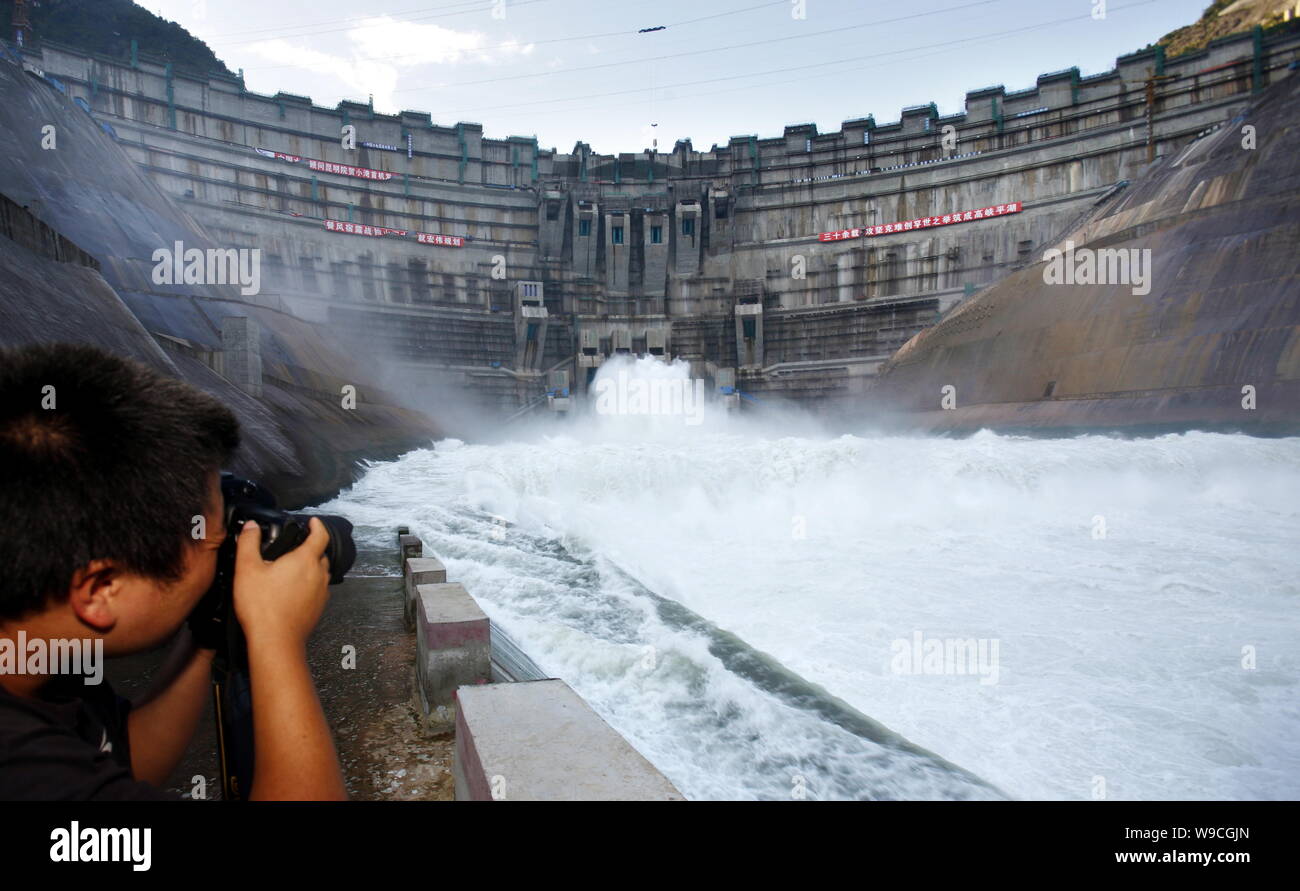A man takes pictures of water being discharged from the dam of the ...