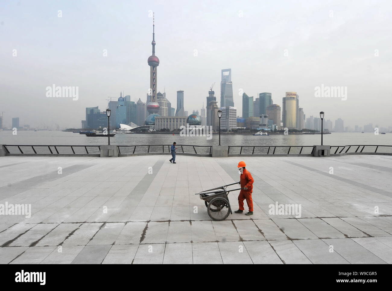 Chinese construction workers labor at the jobsite of the Bund promenade ...
