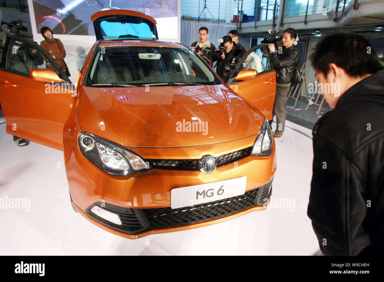 Visitors look at an MG6, manufactured by SAIC Motor, during a launch ...