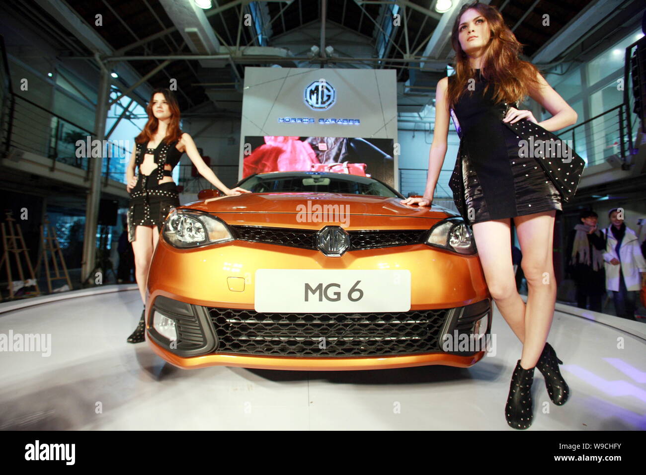 Models pose with an MG6, manufactured by SAIC Motor, during a launch ...