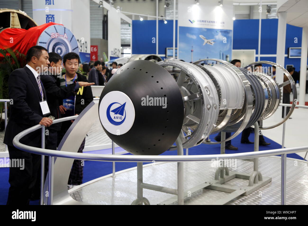 Visitors look at an aircraft enging at the stand of AVIC Commercial ...