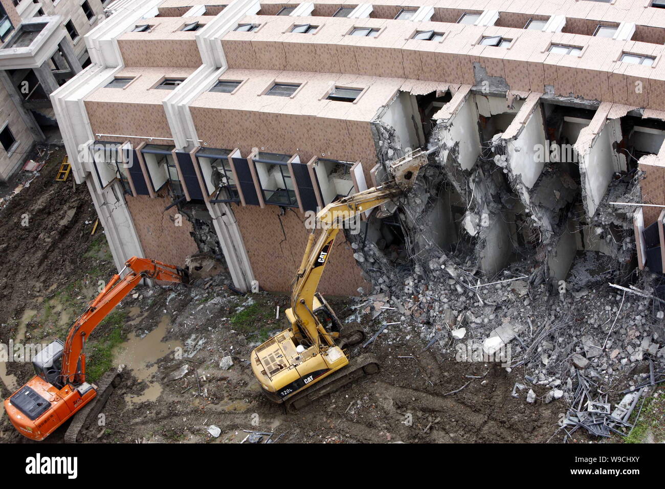 Excavators are seen dismantling the toppled apartment building at the ...