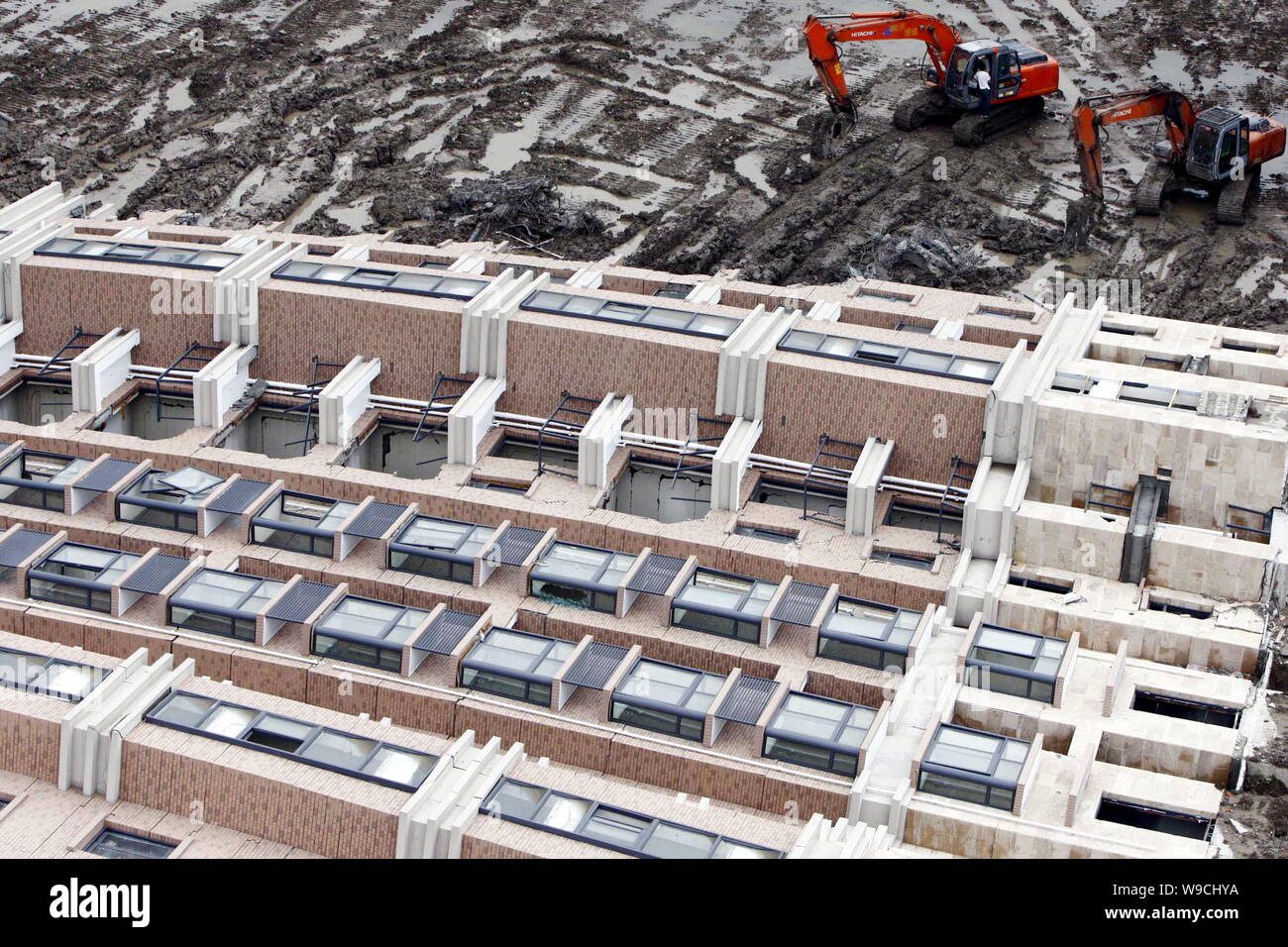 Excavators are seen dismantling the toppled apartment building at the ...