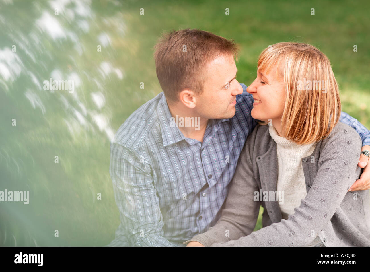 Happy young couple hugging and laughing together in the park outdoor ...
