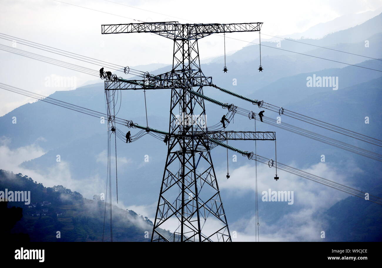 Chinese electricians install electrical wires on a pylon near the ...