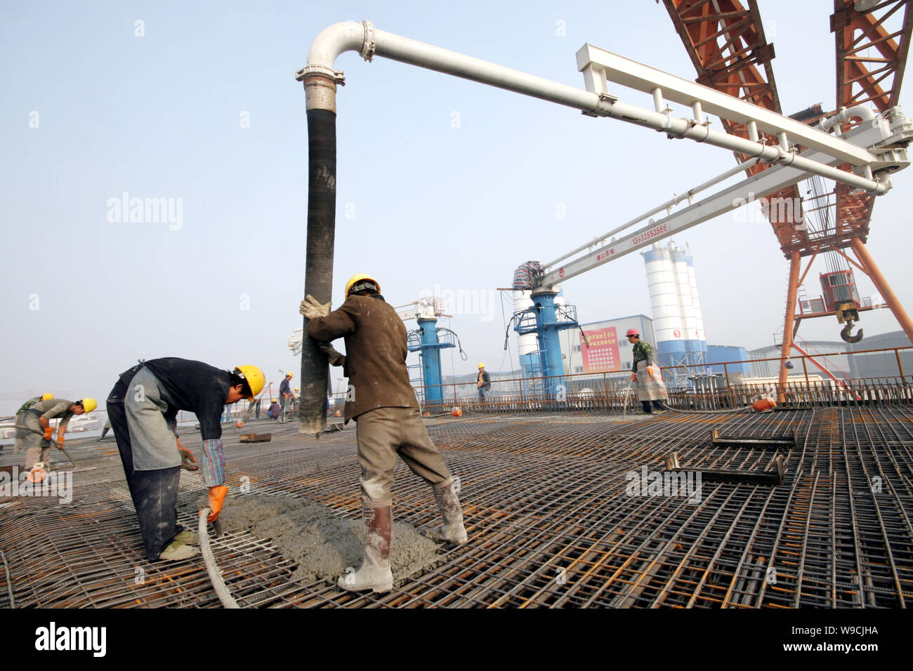 Chinese building workers construct the foundation for a section of the ...