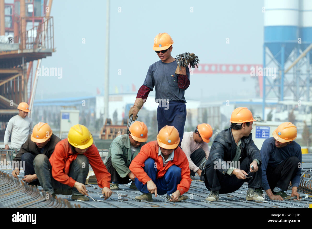 Chinese building workers construct the foundation for a section of the ...