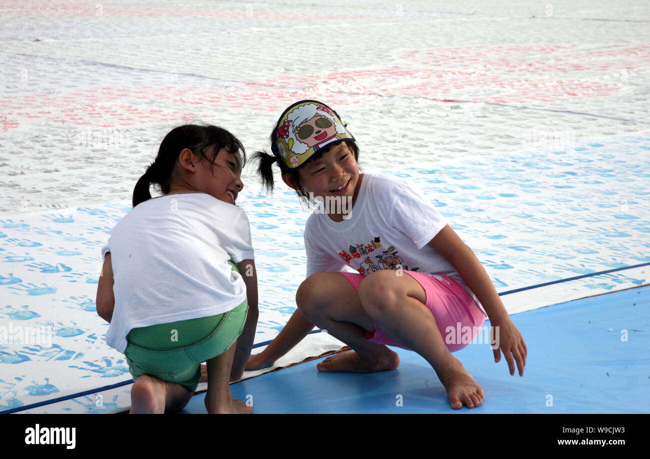 Young Chinese girls leave their handprints on a huge handprint painting ...