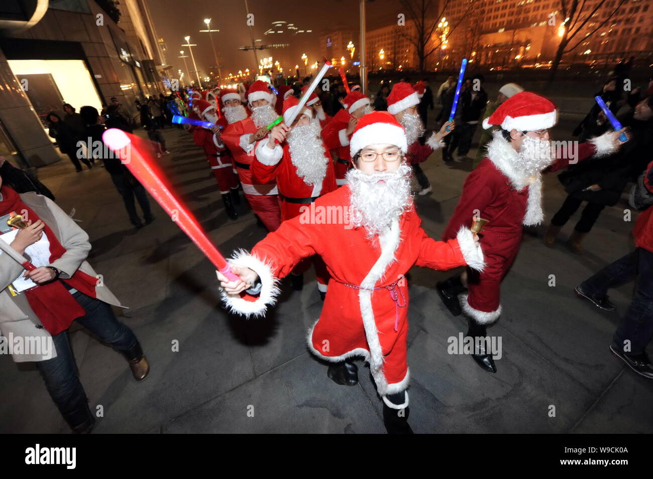 Chinese Santa Clauses celebrate on a shopping street on Christmas Eve ...