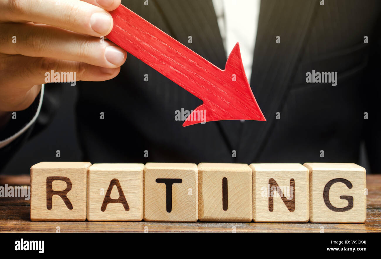 A man holds a red down arrow above the word Rating. The concept of ...