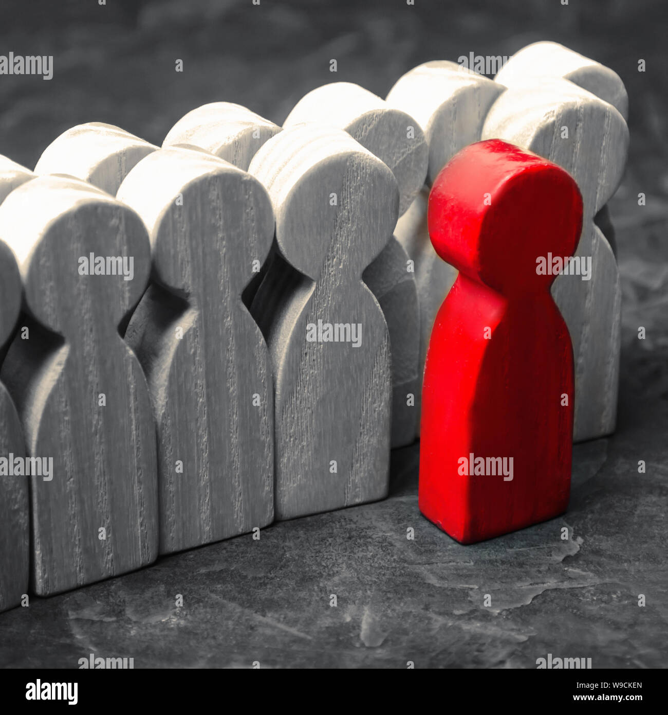 Wooden figures of people. The red man comes out with a team of workers ...