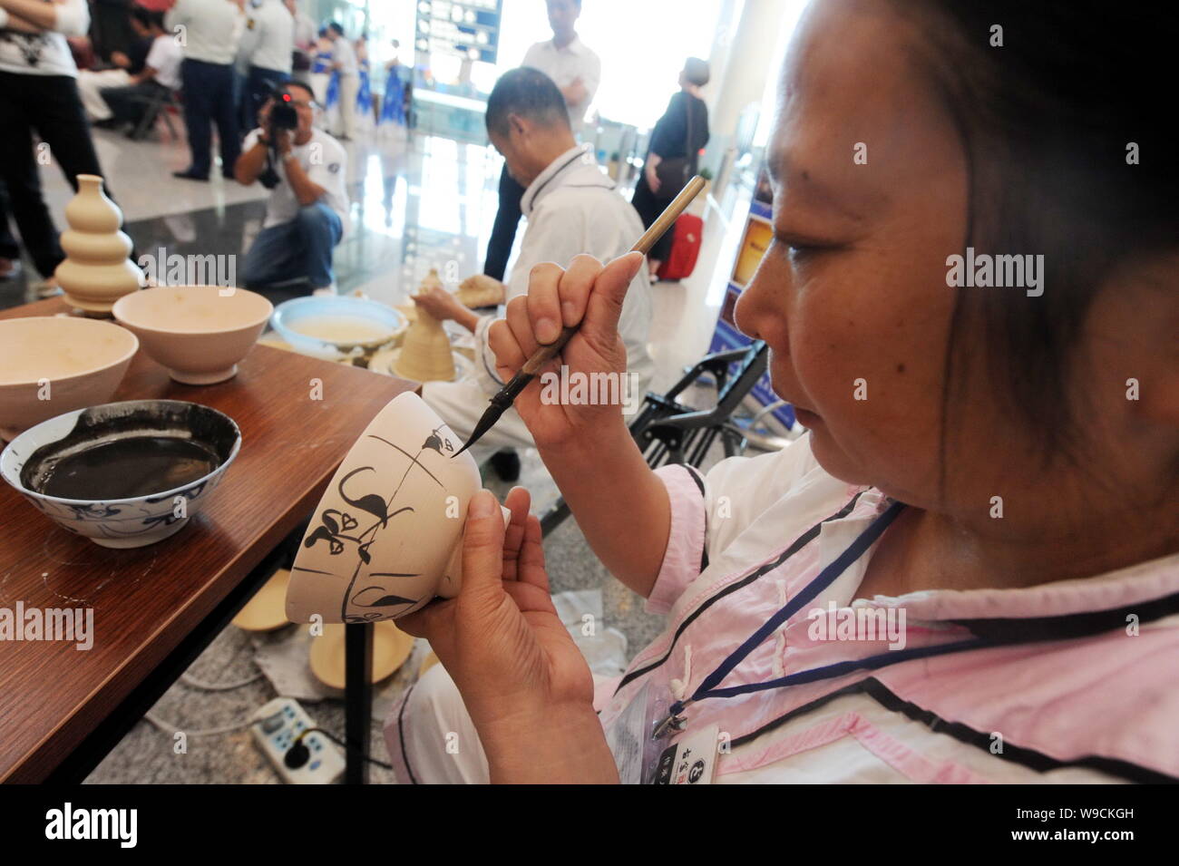 Chinese craftsmen make porcelain wares during a show to promote the ...