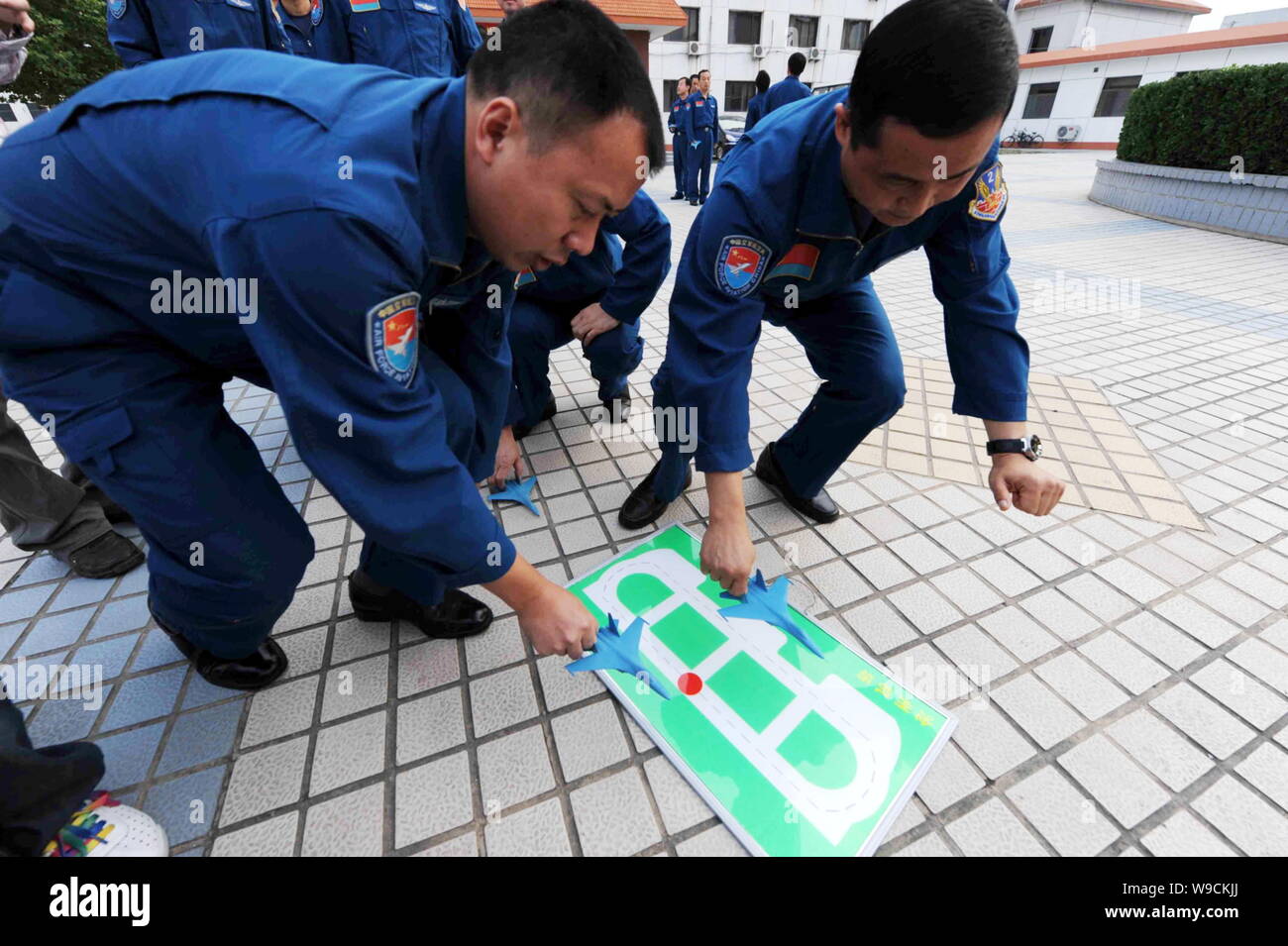 Chinese PLA Air Force pilots holding model fighter planes practise ...