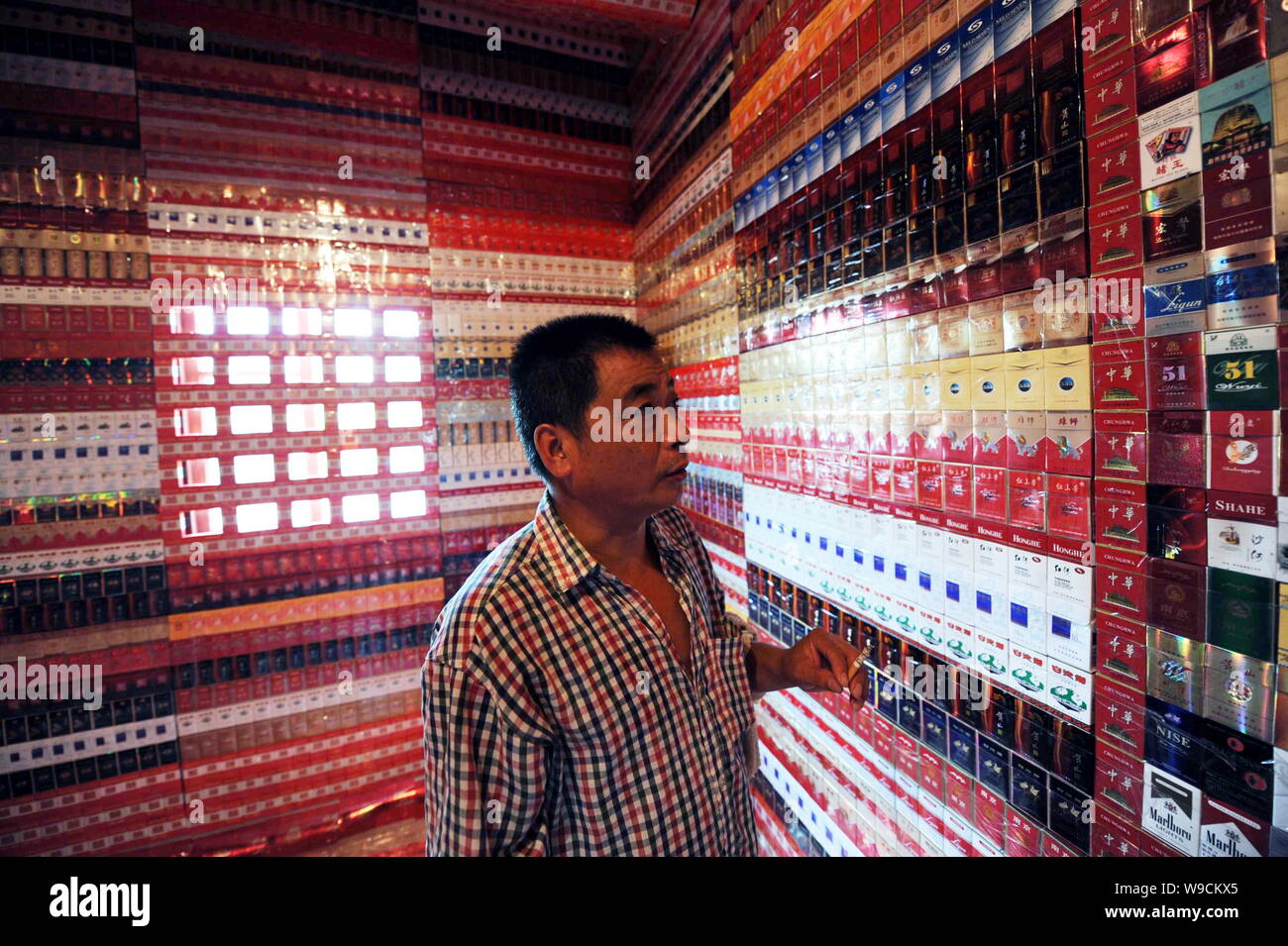 Chinese collector Wang Guohua looks at his collections of cigarette ...
