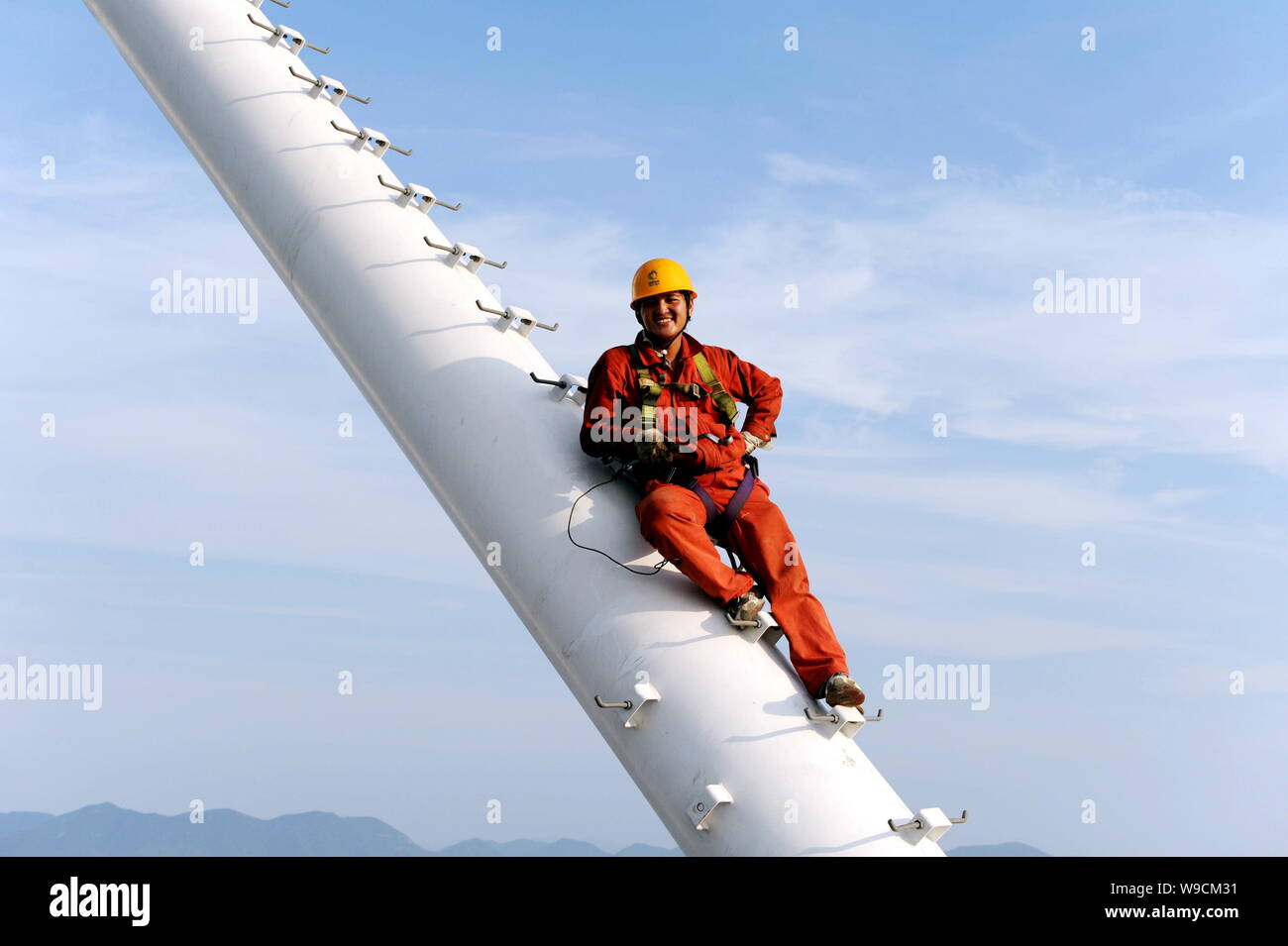 A Chinese construction worker is seen on a 370-meter-tall pylon under ...