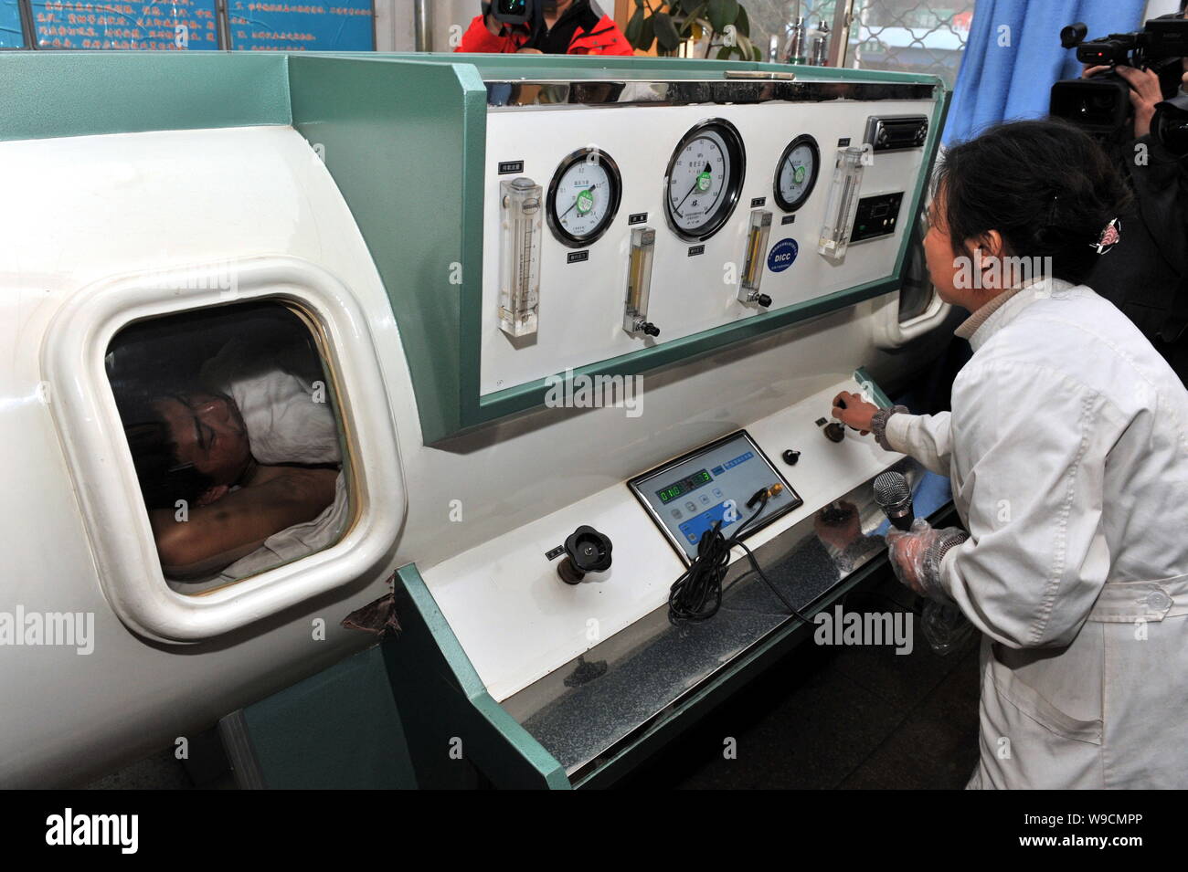 A Chinese doctor operates a high pressure oxygen cabin to treat a coal ...