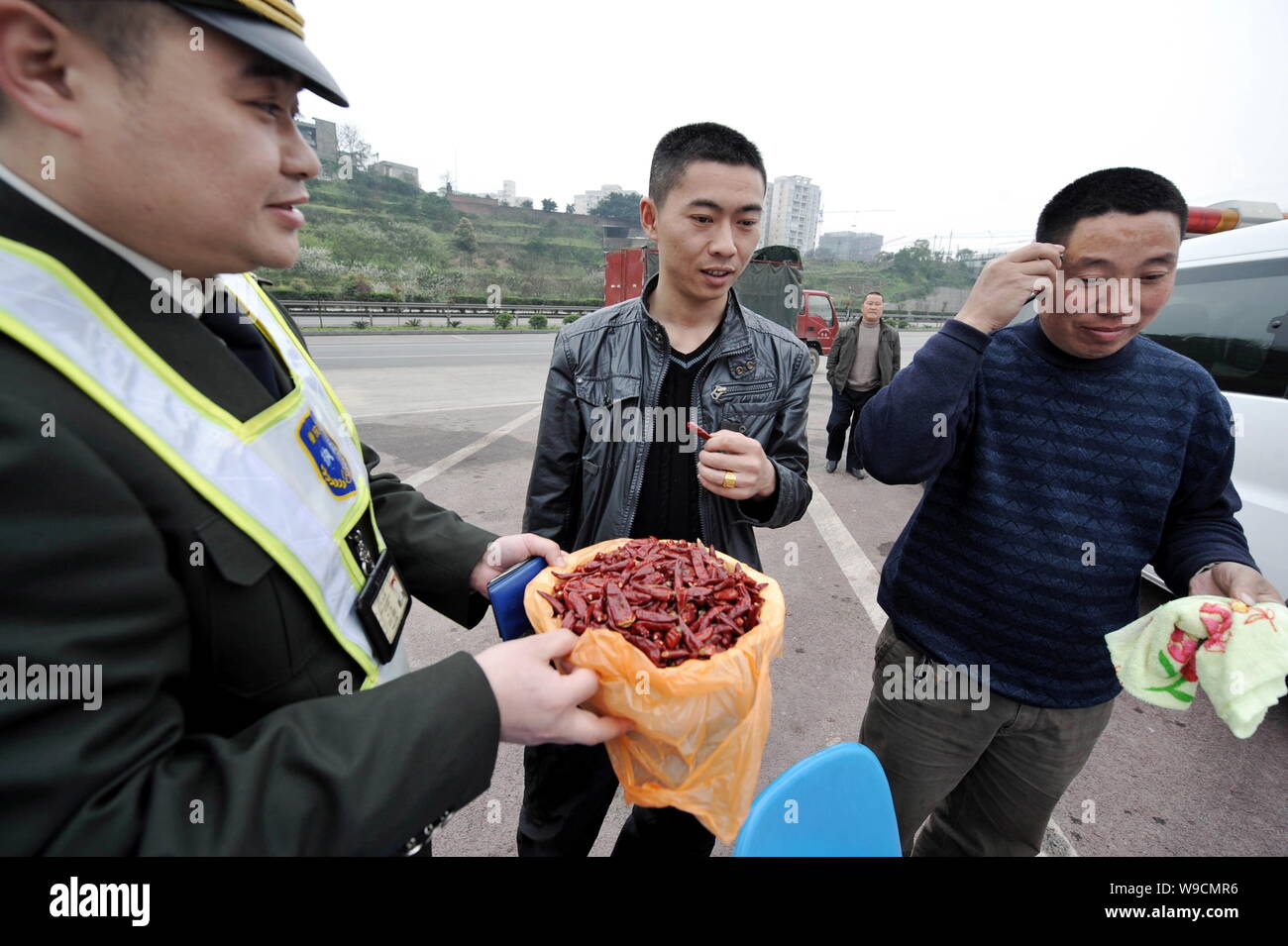 A Chinese police officer offers hot chili peppers to drivers at a ...