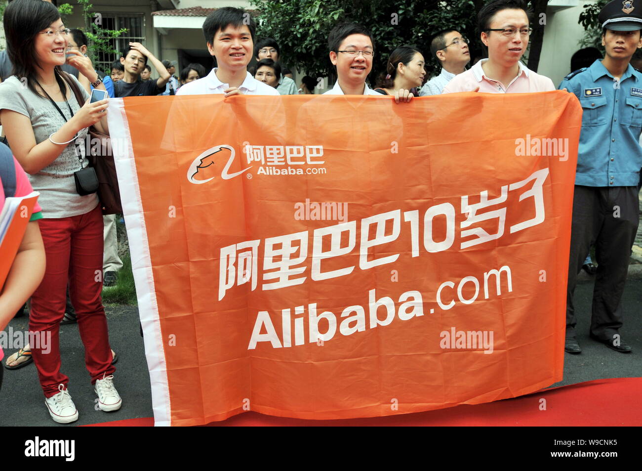 Chinese employees of Alibaba shows the Alibaba flag to celebrate the ...