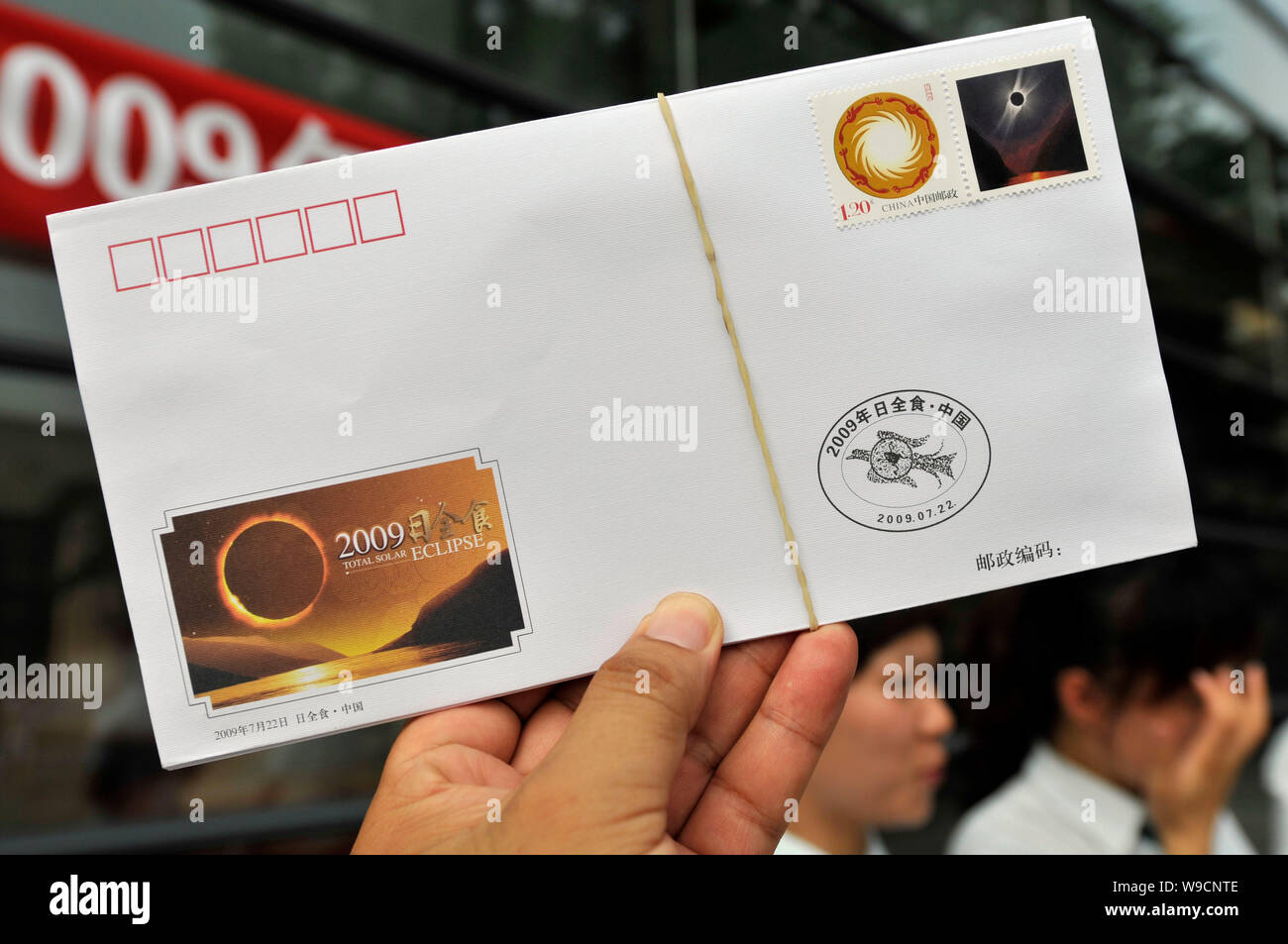 A worker shows first-day covers jointly issued by Beijing Planetarium ...