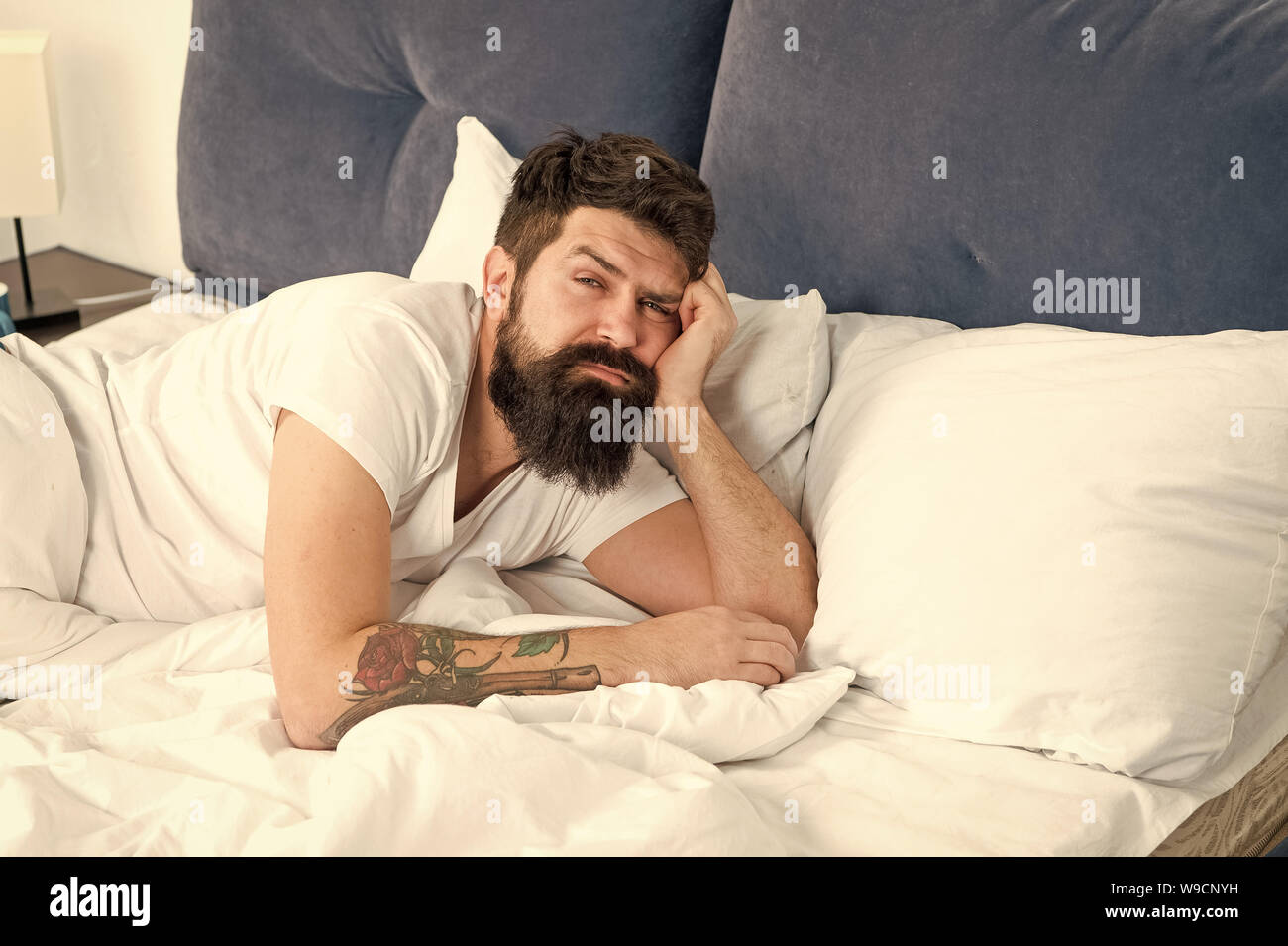 Man bearded hipster woke up too early and feels sleepy and tired. Early ...