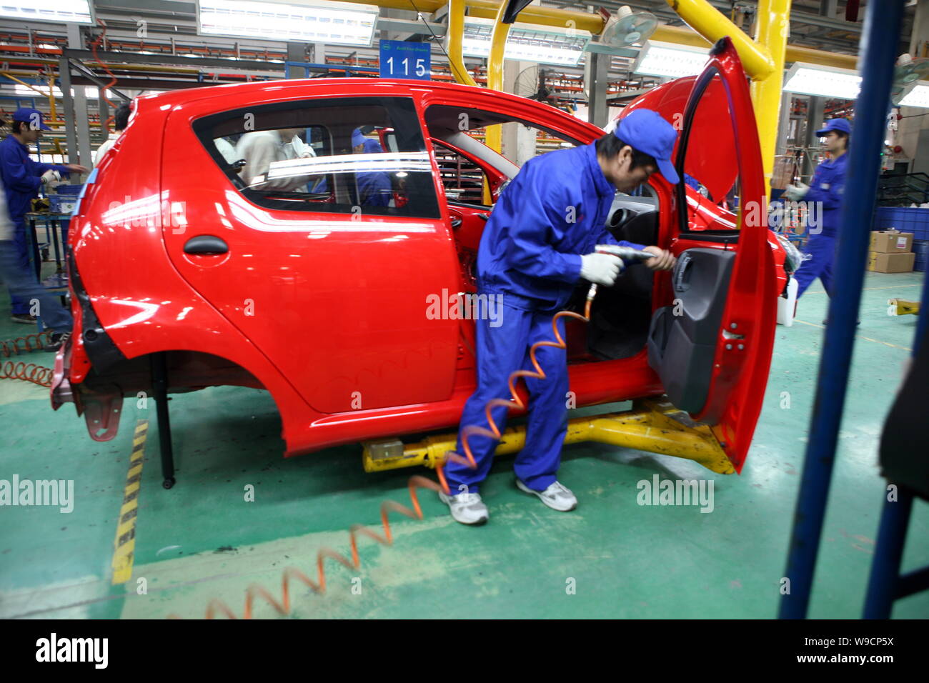Chinese factory workers assemble a BYD car on the production line at ...