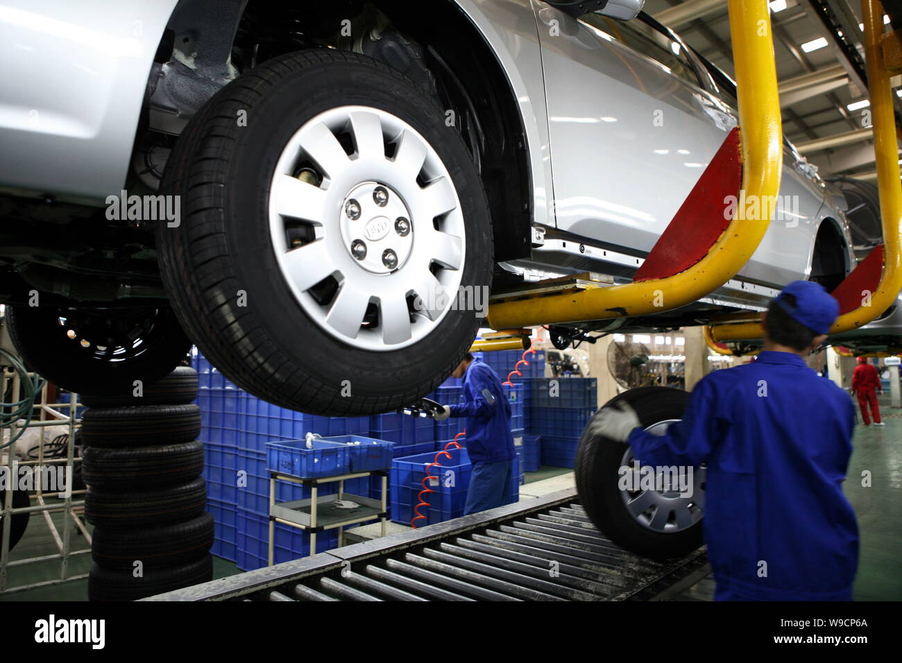 Chinese factory workers assemble a BYD car on the production line at ...