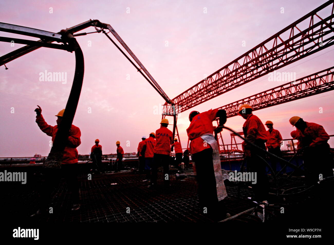 Chinese building workers construct the foundation for a section of the ...
