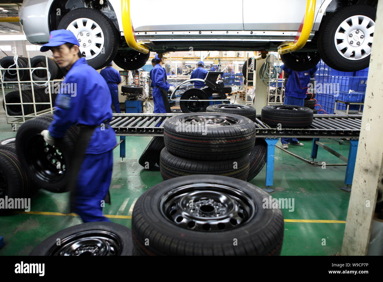 Chinese factory workers assemble a BYD car on the production line at ...