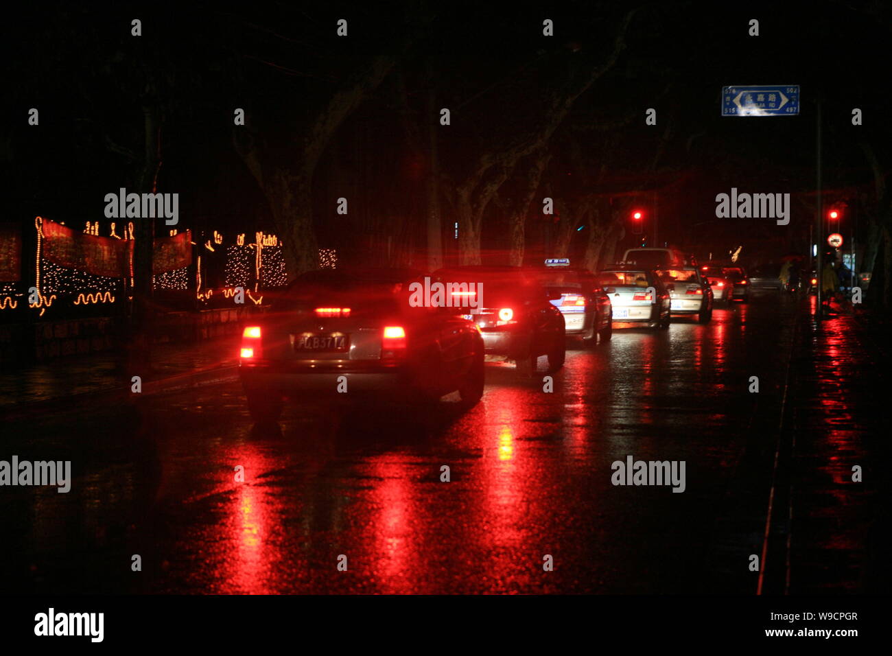 Cars are seen driving on a street during a total solar eclipse in ...