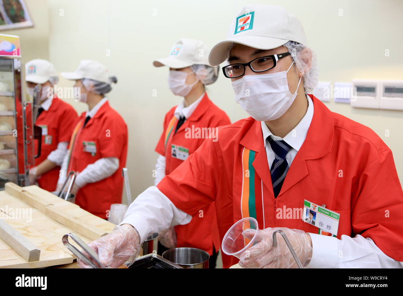 Chinese employees are seen serving customers at a 7-Eleven convenience ...