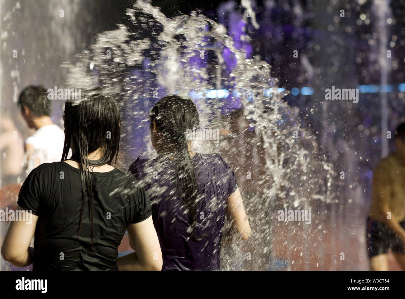 Chinese tourists and local citizens splash water during a water ...