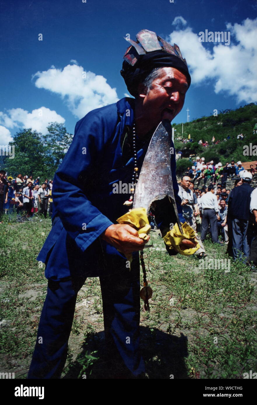 --FILE-- An old Qiang man licks a metal tool during the Mountain ...