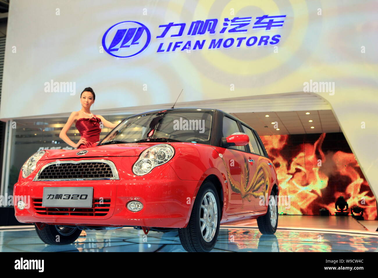 A model poses with a Lifan 320 minicar at the 13th Shanghai ...