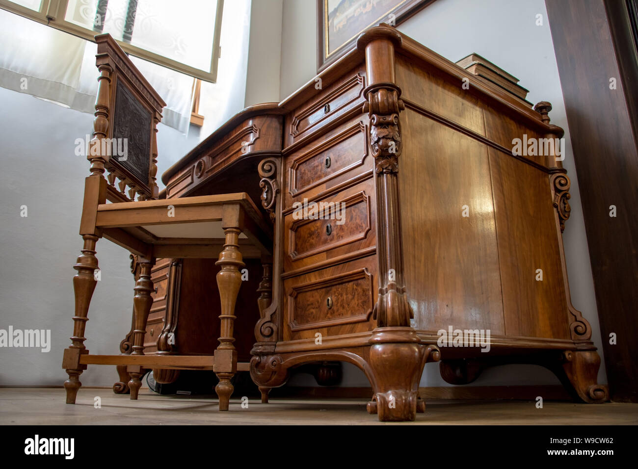 The old wooden table with seat, look from below. Historical office with ...