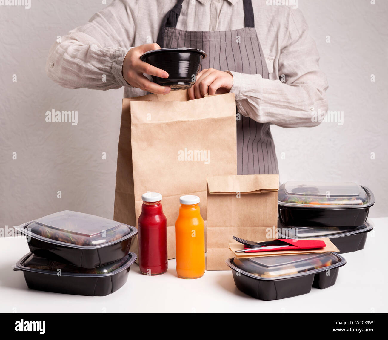 Woman in cooking clothes folding healthy food to go Stock Photo - Alamy