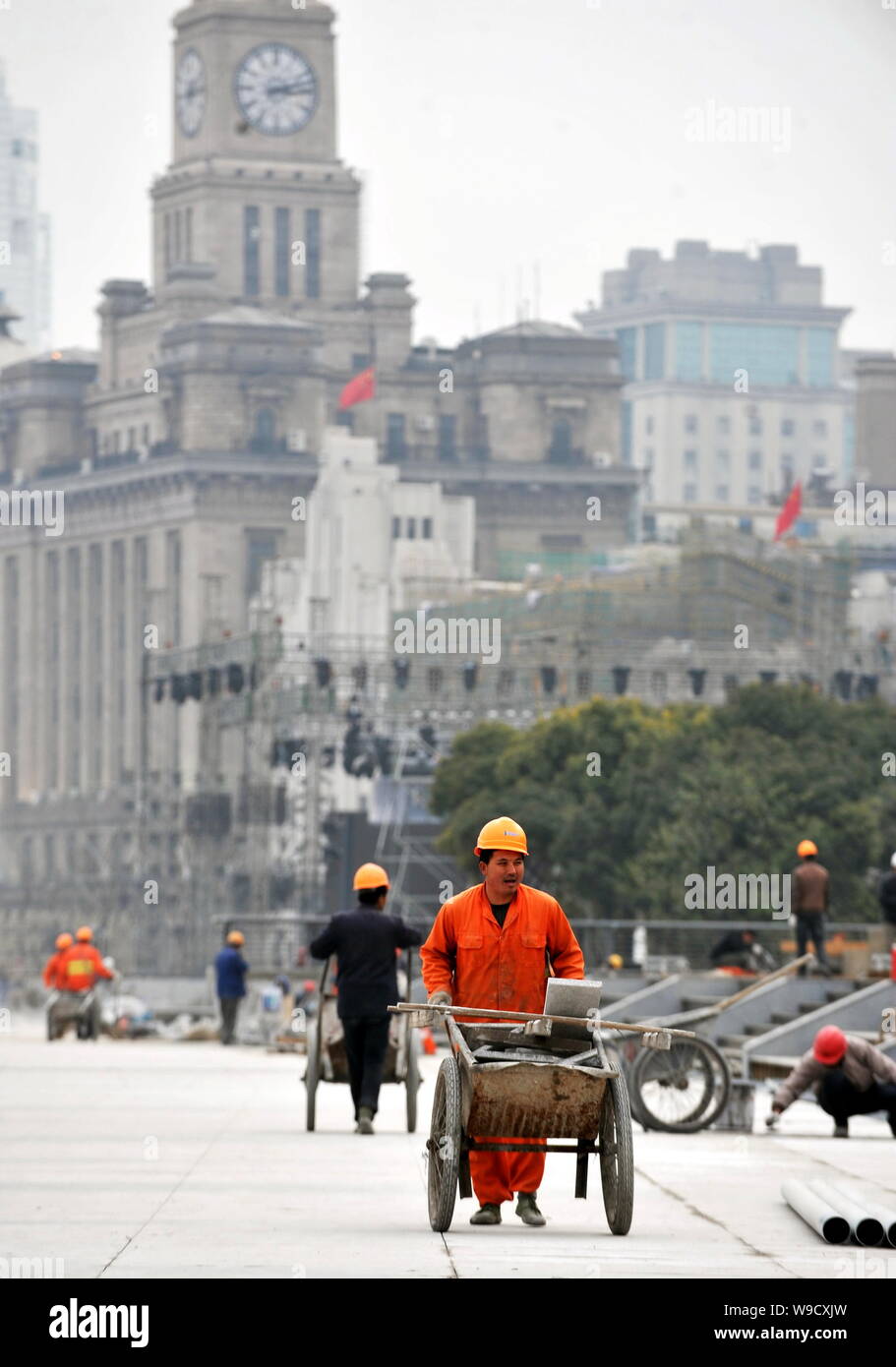 Chinese construction workers labor at the jobsite of the Bund promenade ...