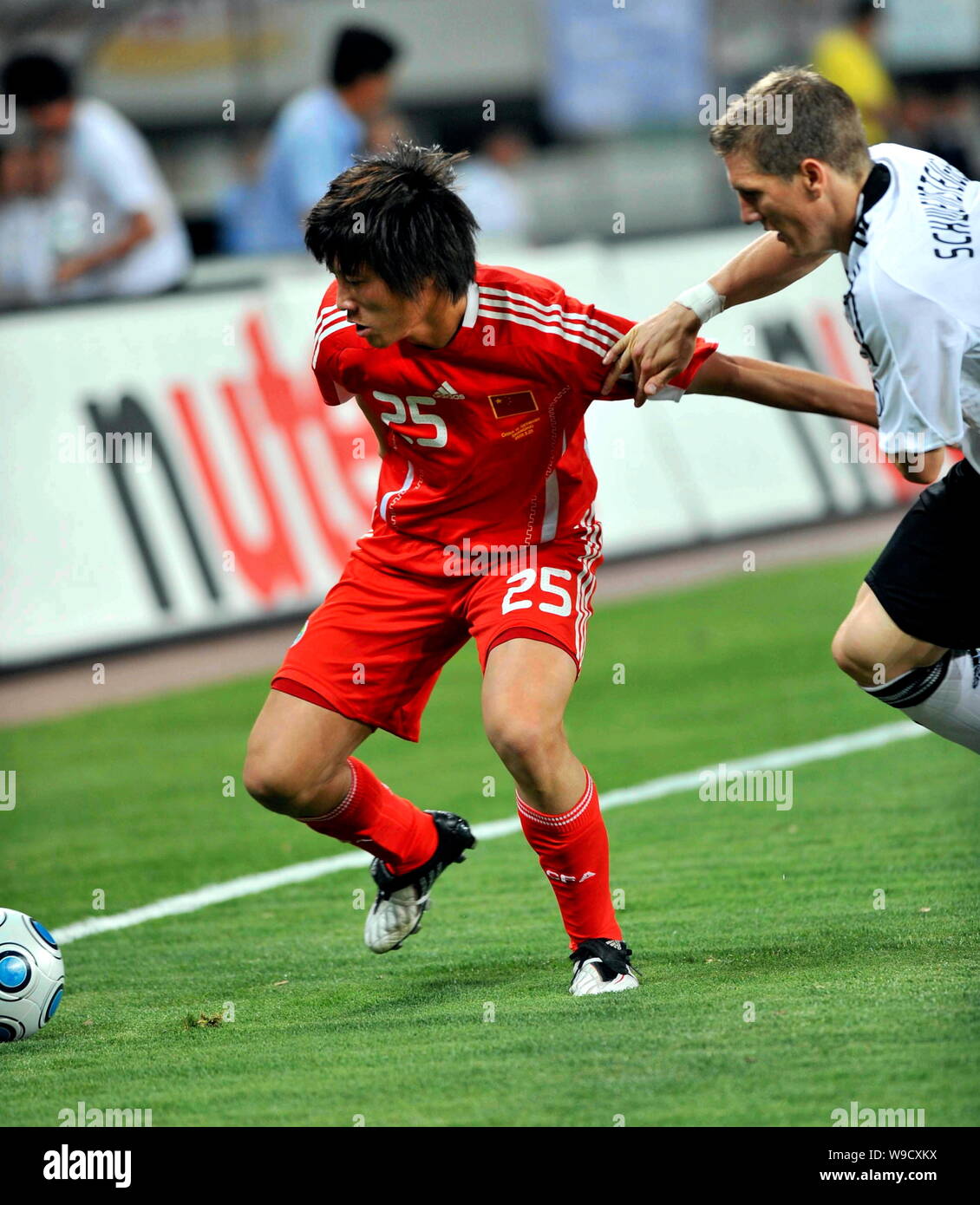 Chinas Zhao Peng, left, competes with Bastian Schweinsteiger of Germany ...