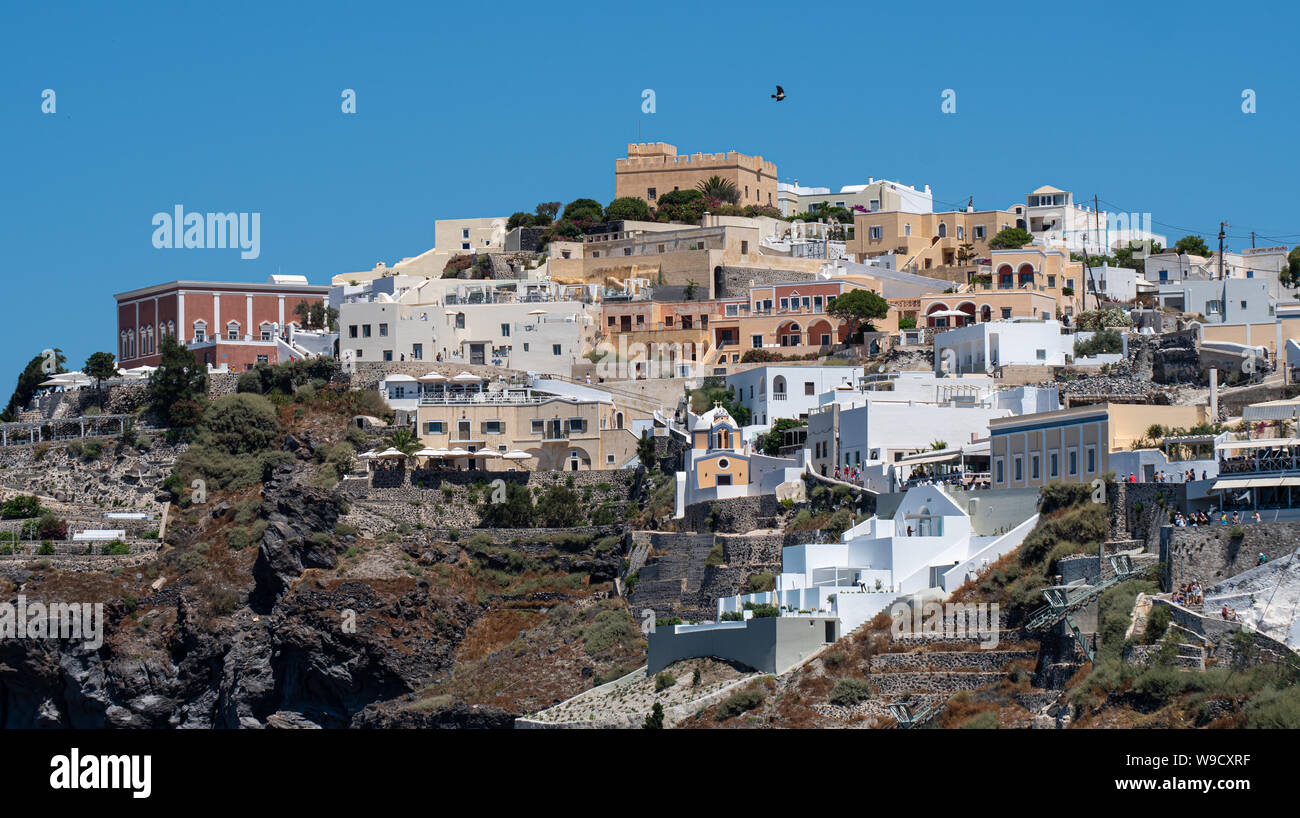 The buildings crowded into the top of the cliff in the Snatorini ...