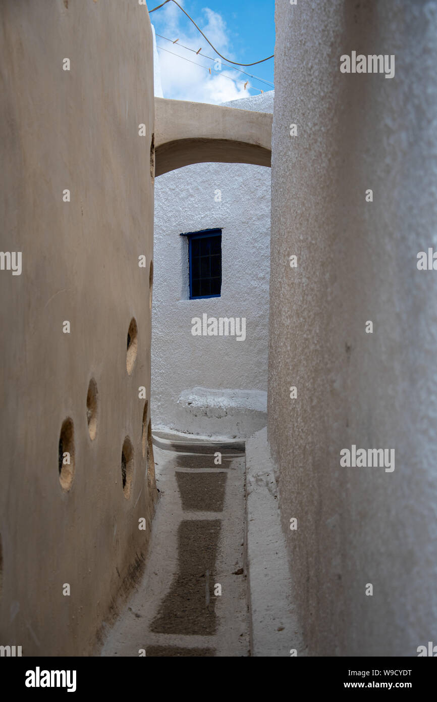 A narrow path leads betweeen two houses in ancient Emporio on Santorini ...