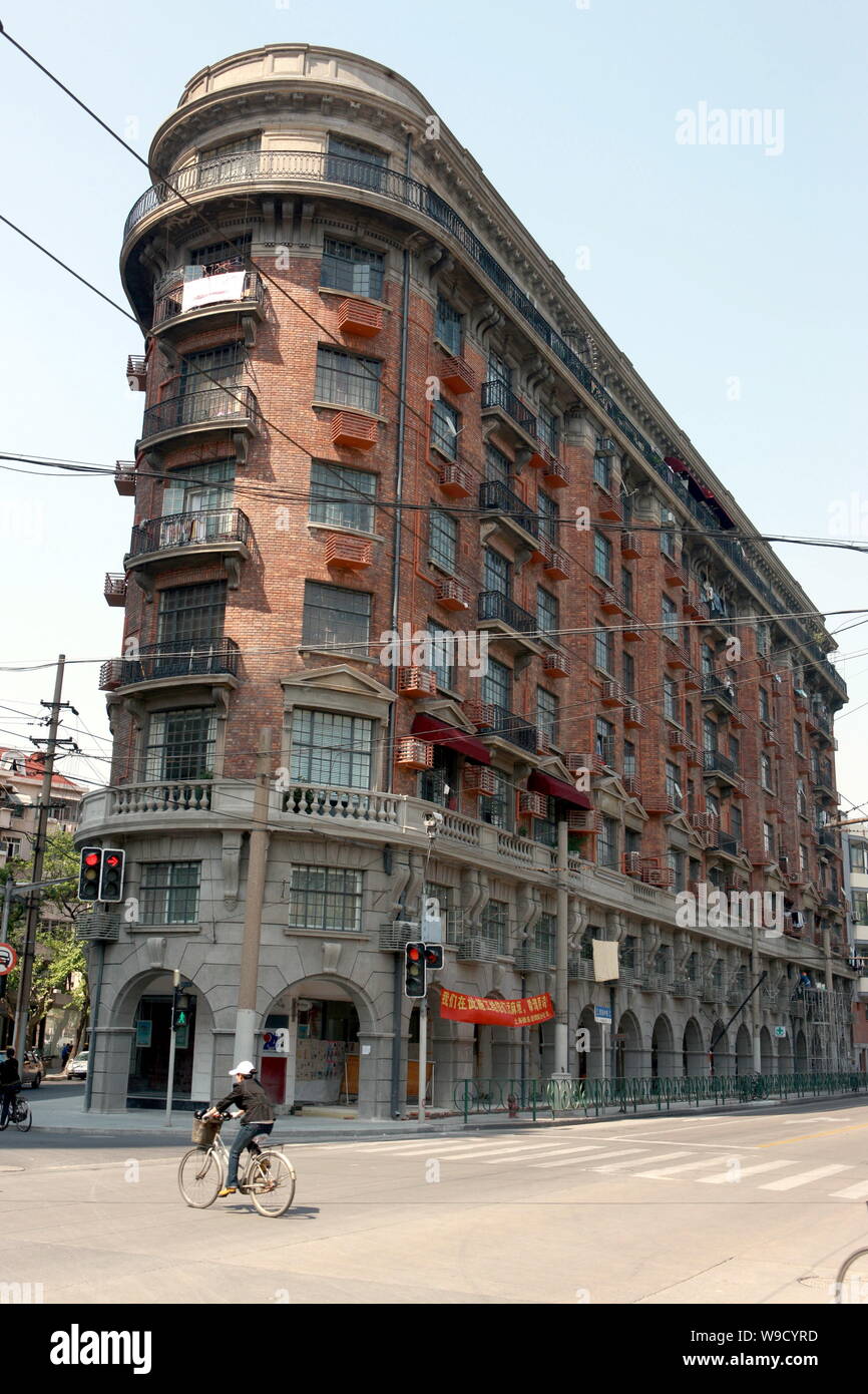 A Chinese cyclist rides past Wukang Building, formerly called Normandie ...