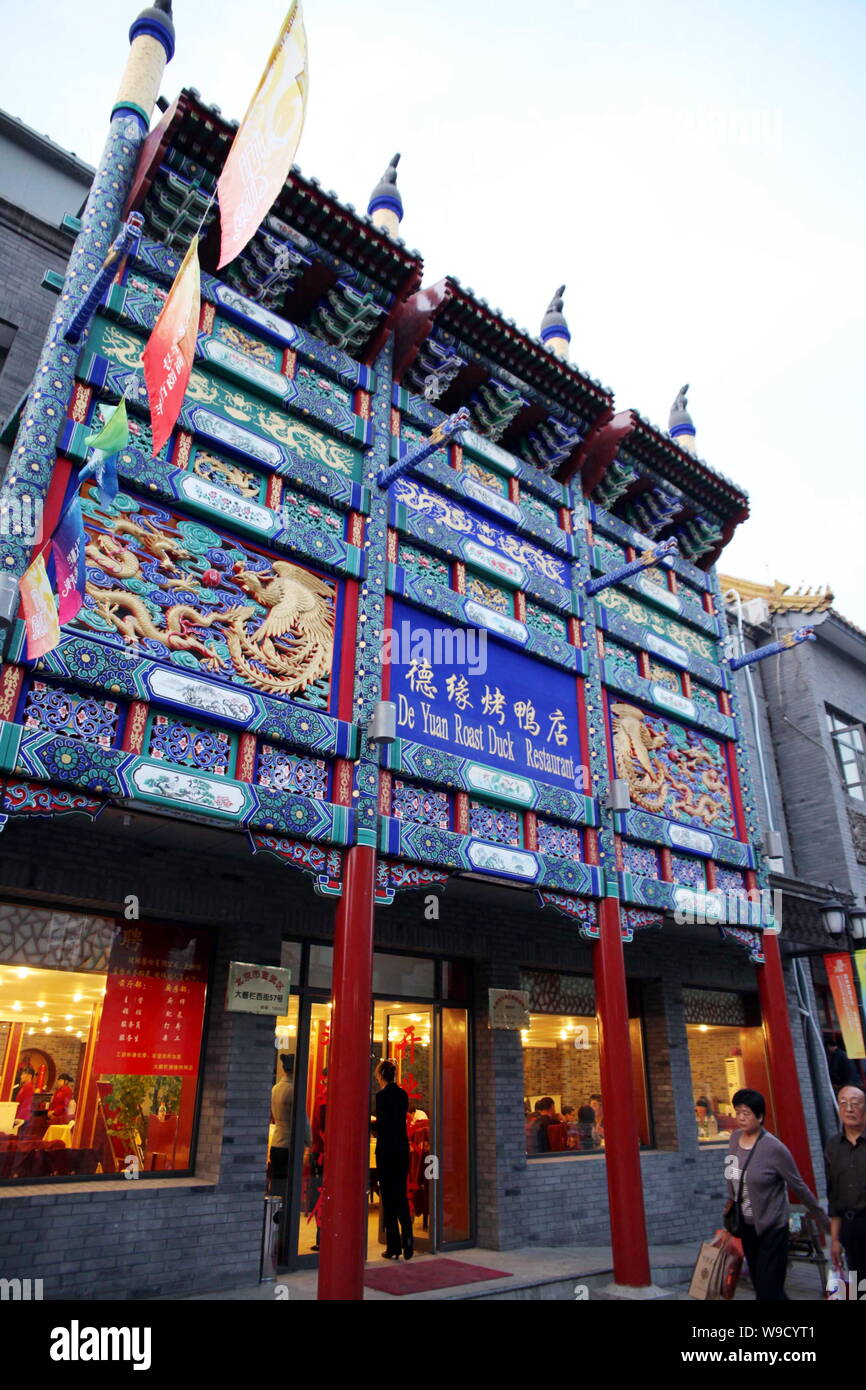 Tourists walk past the De Yuan roast duck restaurant on the Dazhalan ...