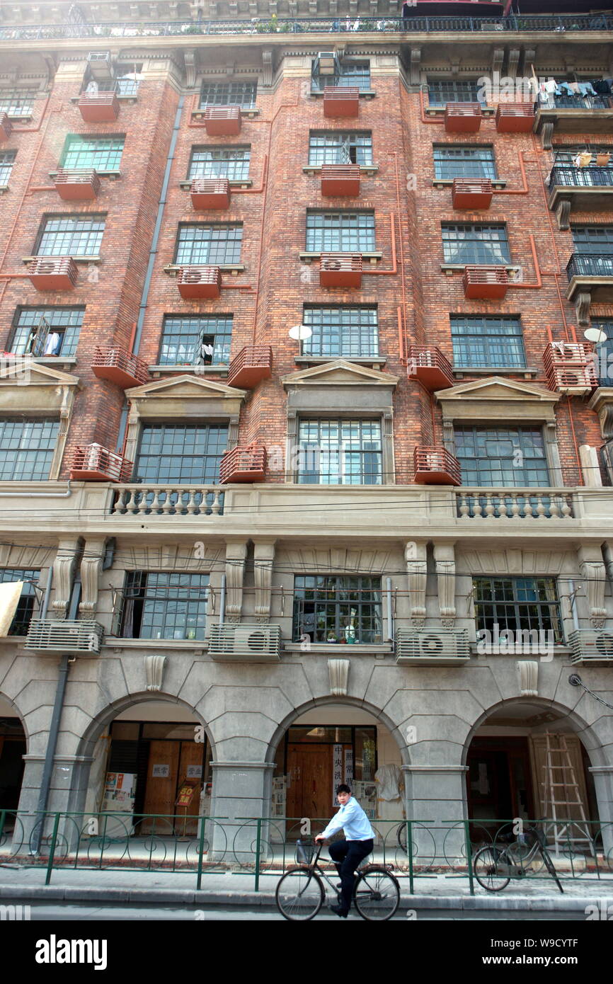 A Chinese cyclist rides past Wukang Building, formerly called Normandie ...