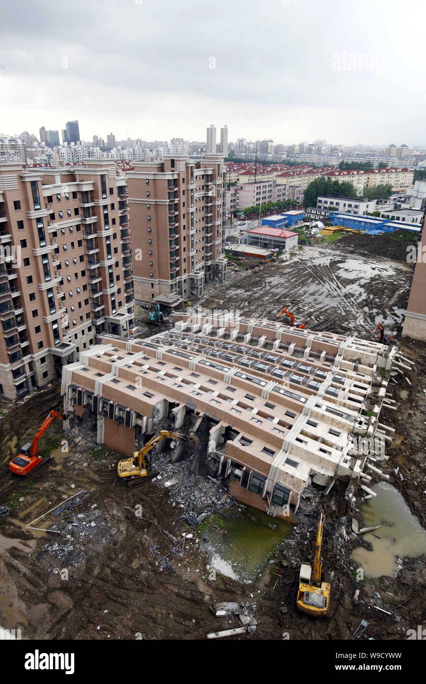 Excavators are seen dismantling the toppled apartment building at the ...